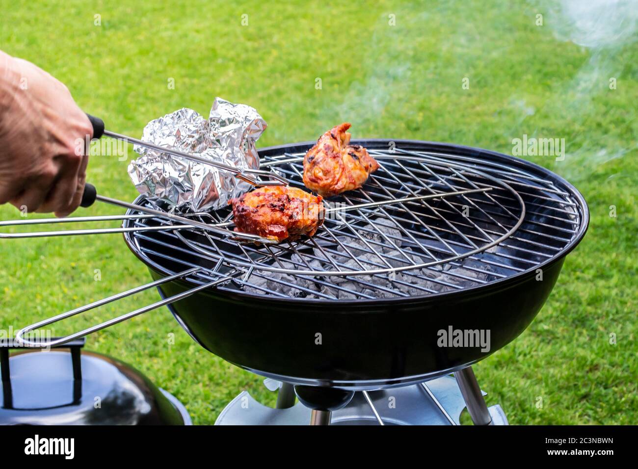 Chicken cooking on a bbq in a garden Stock Photo - Alamy