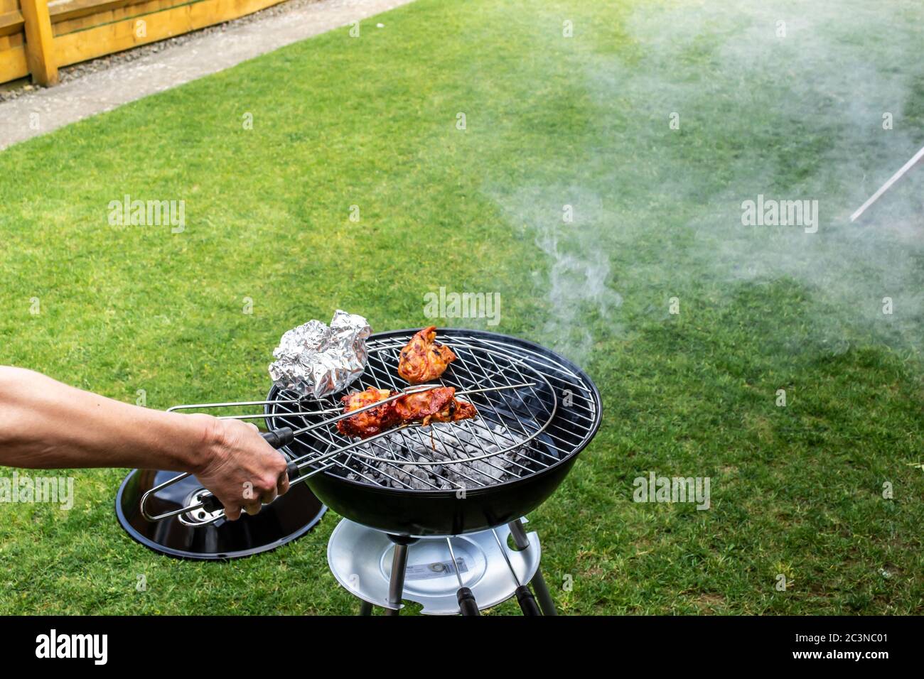 Chicken cooking on a bbq in a garden Stock Photo - Alamy