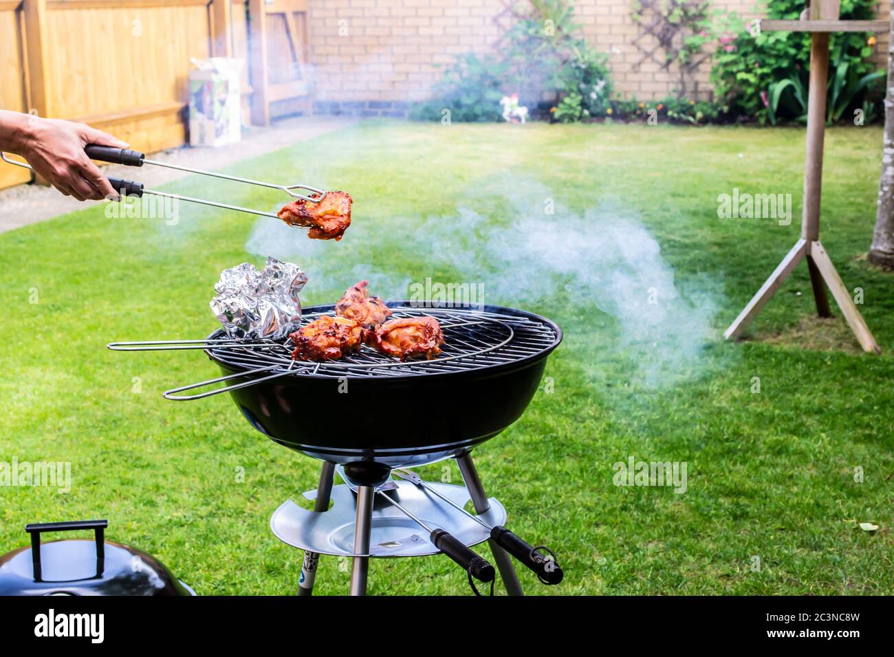 Chicken cooking on a bbq in a garden Stock Photo - Alamy