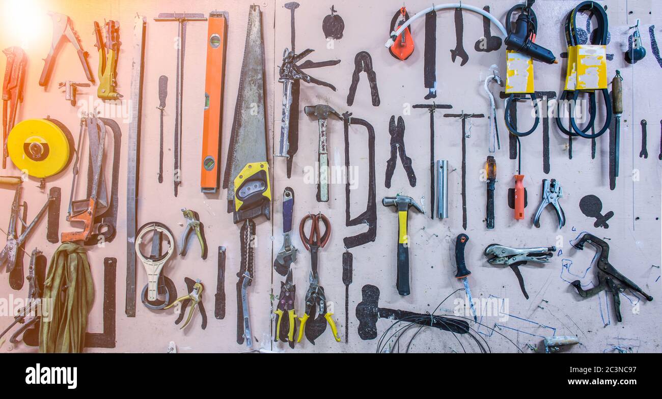 Old tools hanging on wall in workshop.Something's gone Stock Photo - Alamy