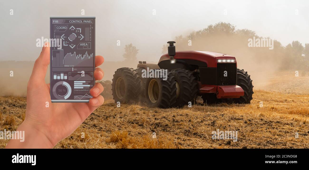 Farmer with digital tablet controls an autonomous tractor and drone on ...