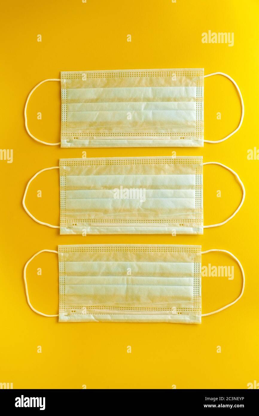 Face masks on yellow background, top view. Medical sanitary surgical ...