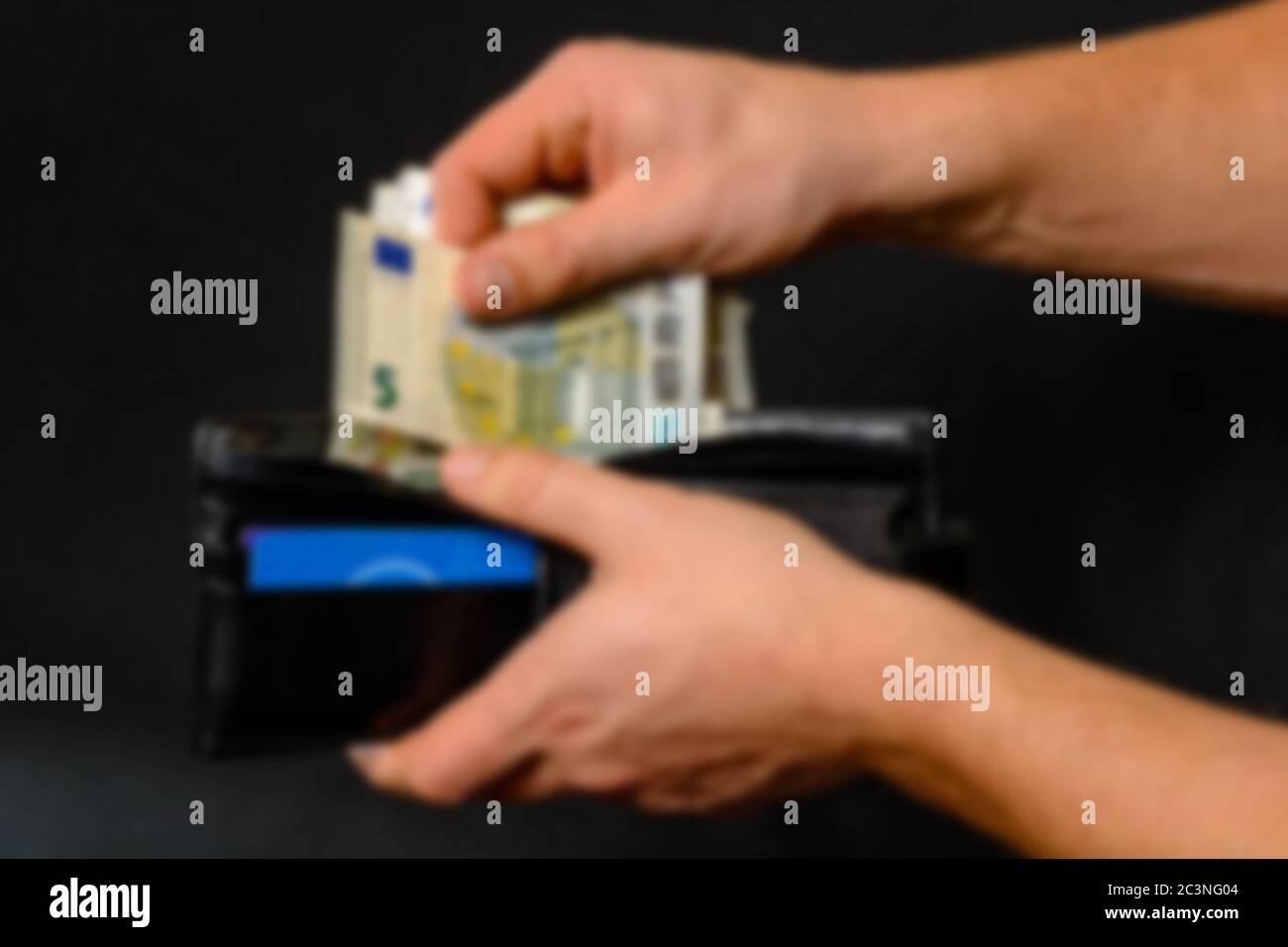 Man hand pulling money from wallet, black background and black wallet ...