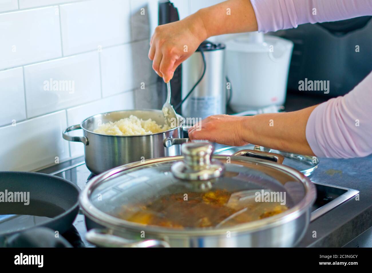 close shot of woman arms cooking in a kitchen taking the pot Stock ...