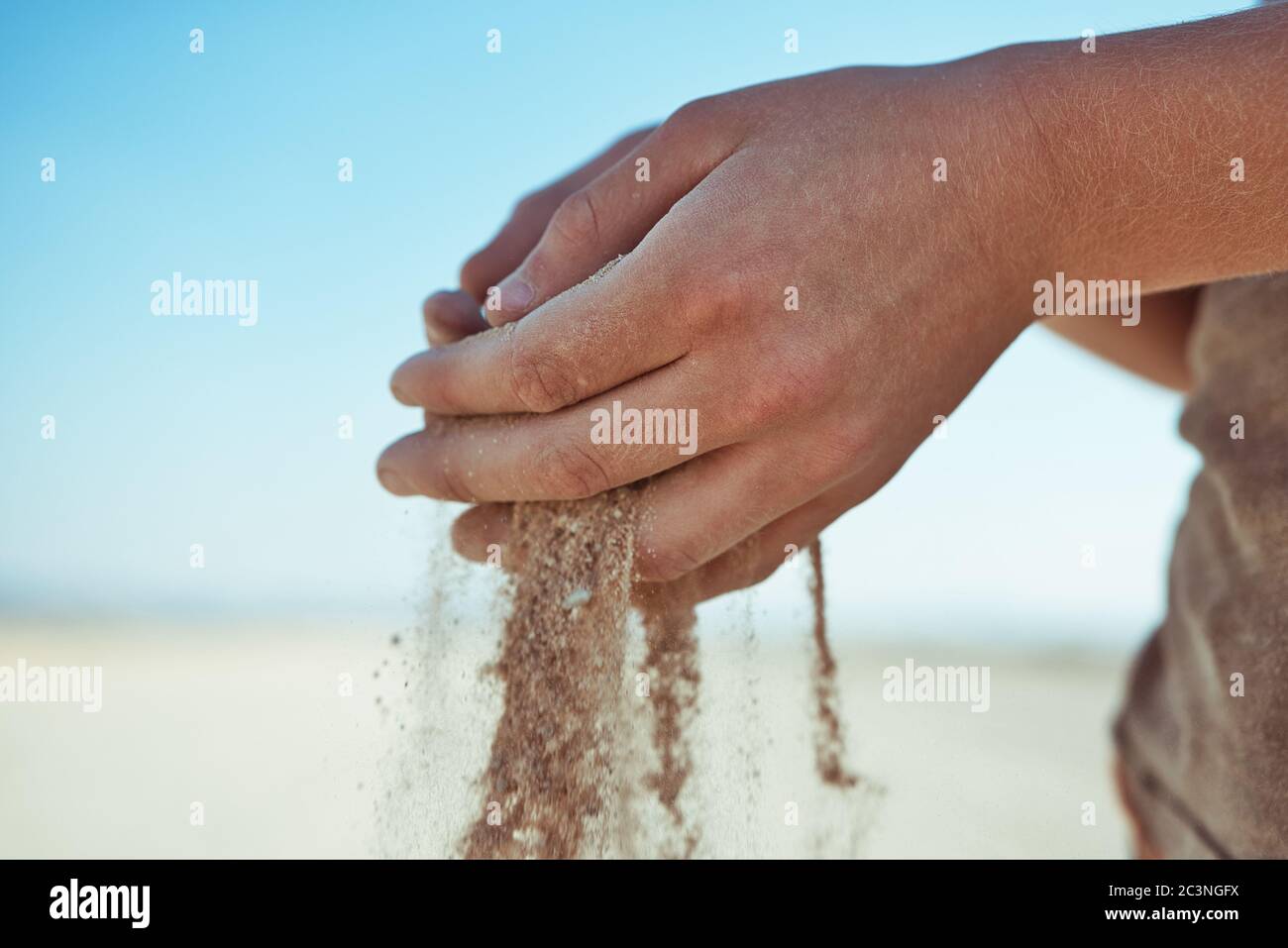 Dropping sand through young kid hands Stock Photo - Alamy