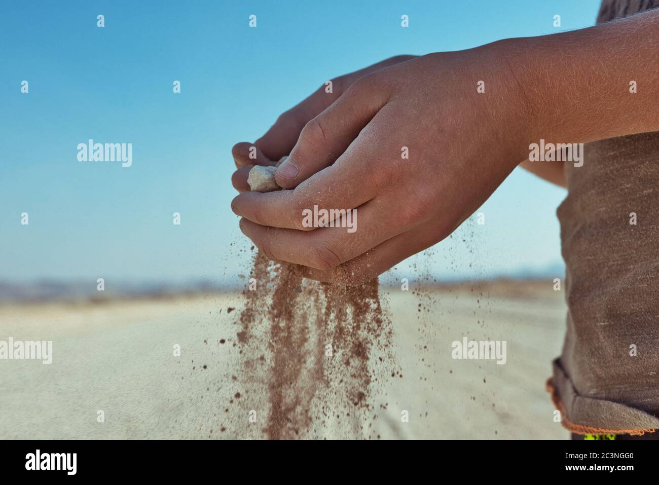 Dropping sand through young kid hands Stock Photo - Alamy