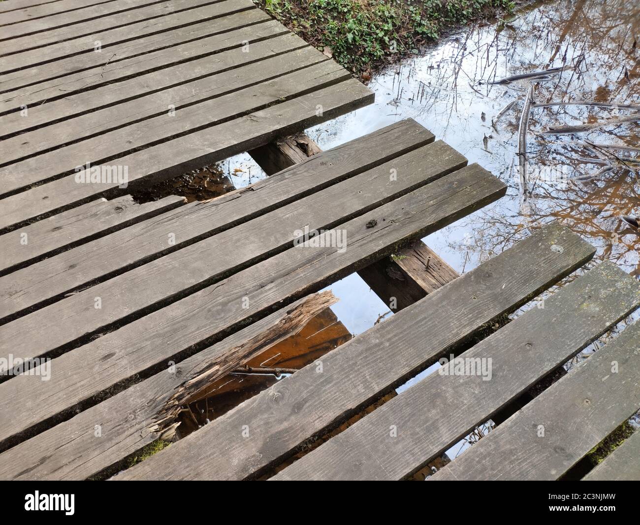 Old damaged broken wooden park bridge with water under the bridge Stock ...