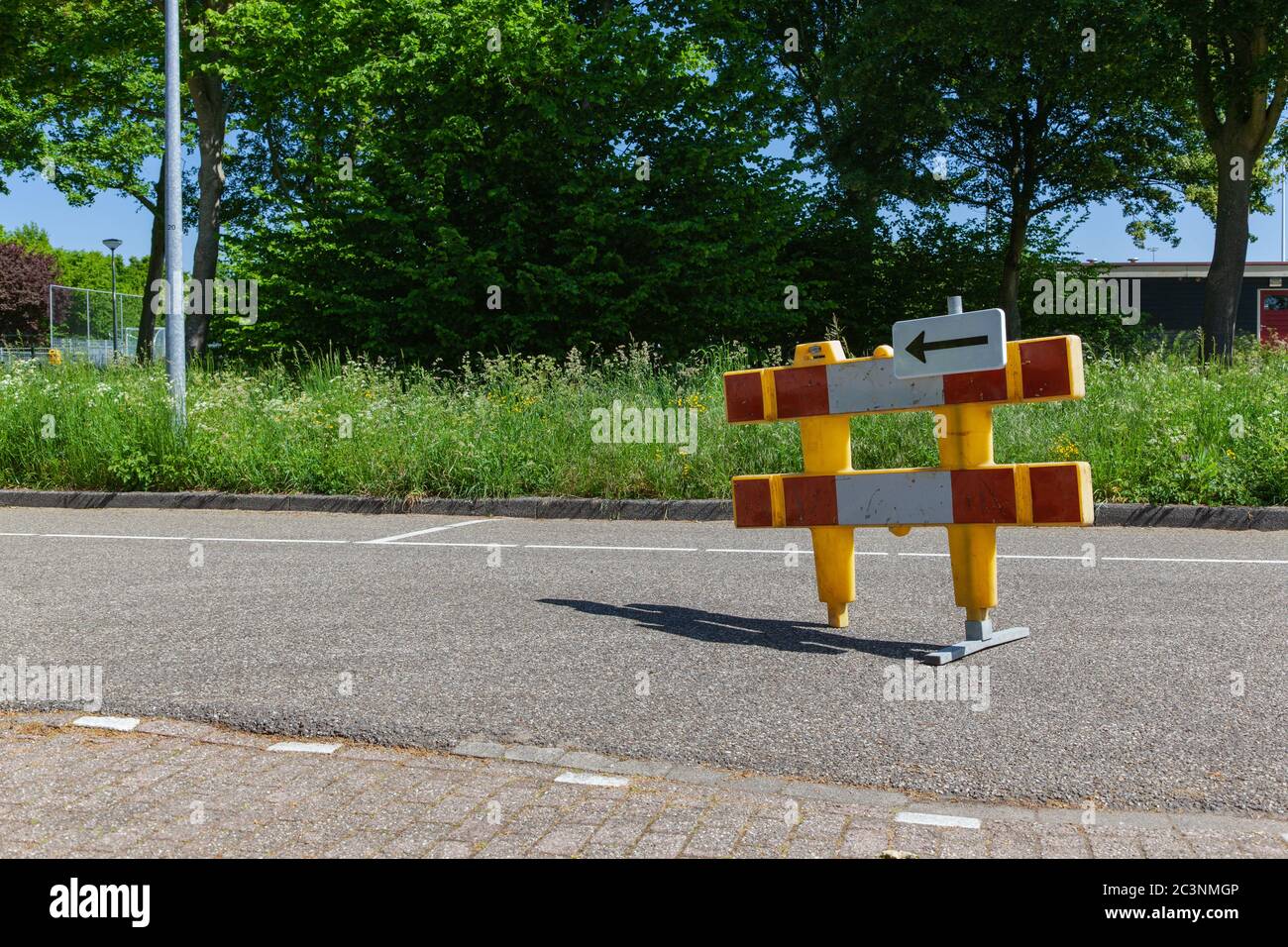 Road sign with an arrow surrounded by trees and grass Stock Photo - Alamy