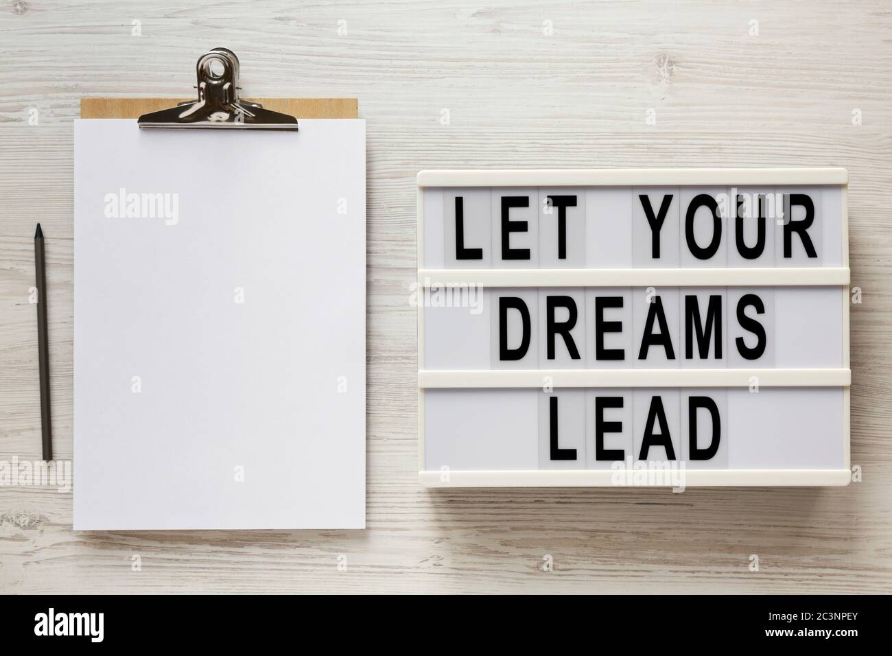 'Let your dreams lead' on a lightbox, clipboard with blank sheet of ...