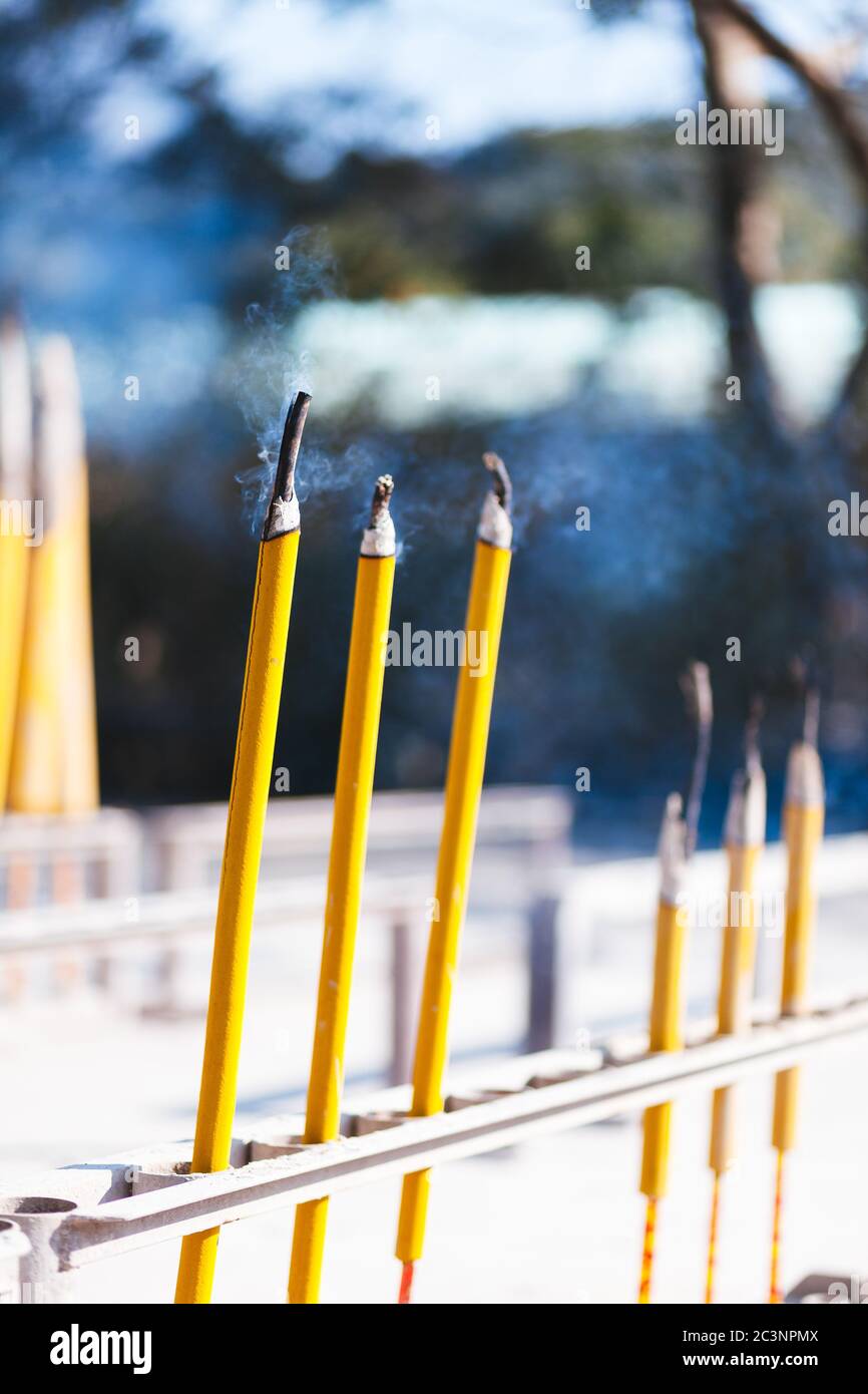 Yellow burning incense sticks outdoors Stock Photo - Alamy
