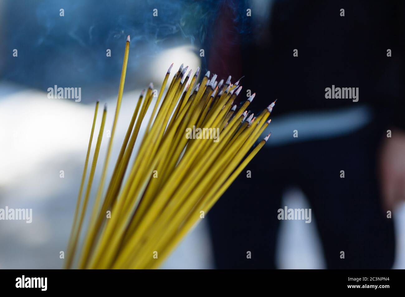 Yellow burning incense sticks outdoors Stock Photo - Alamy