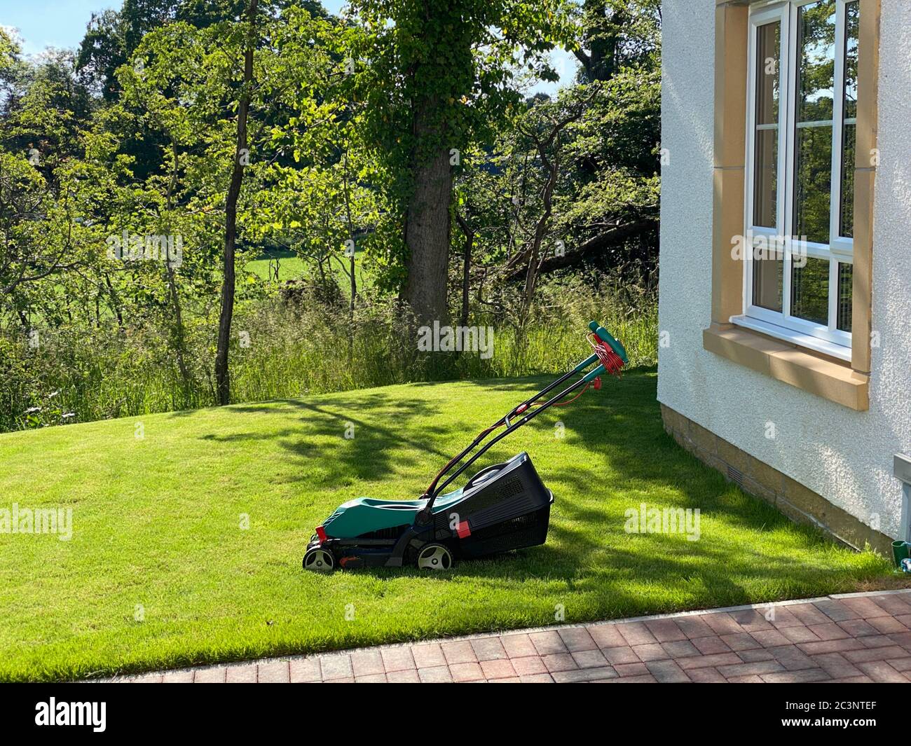 Lawn mower and fresh cut garden grass Stock Photo - Alamy