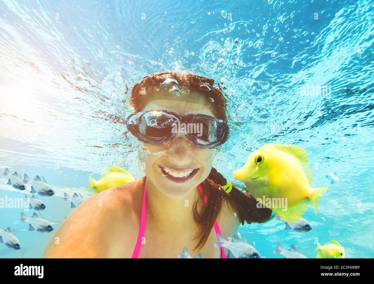 Smiling little girl in swim goggles swimming underwater in pool ... Smiling little girl in swim goggles swimming underwater in pool ...