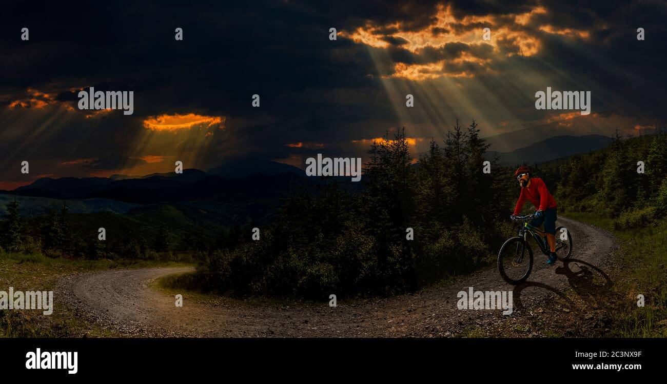 Cycling man riding on bike at sunset mountains forest landscape ...