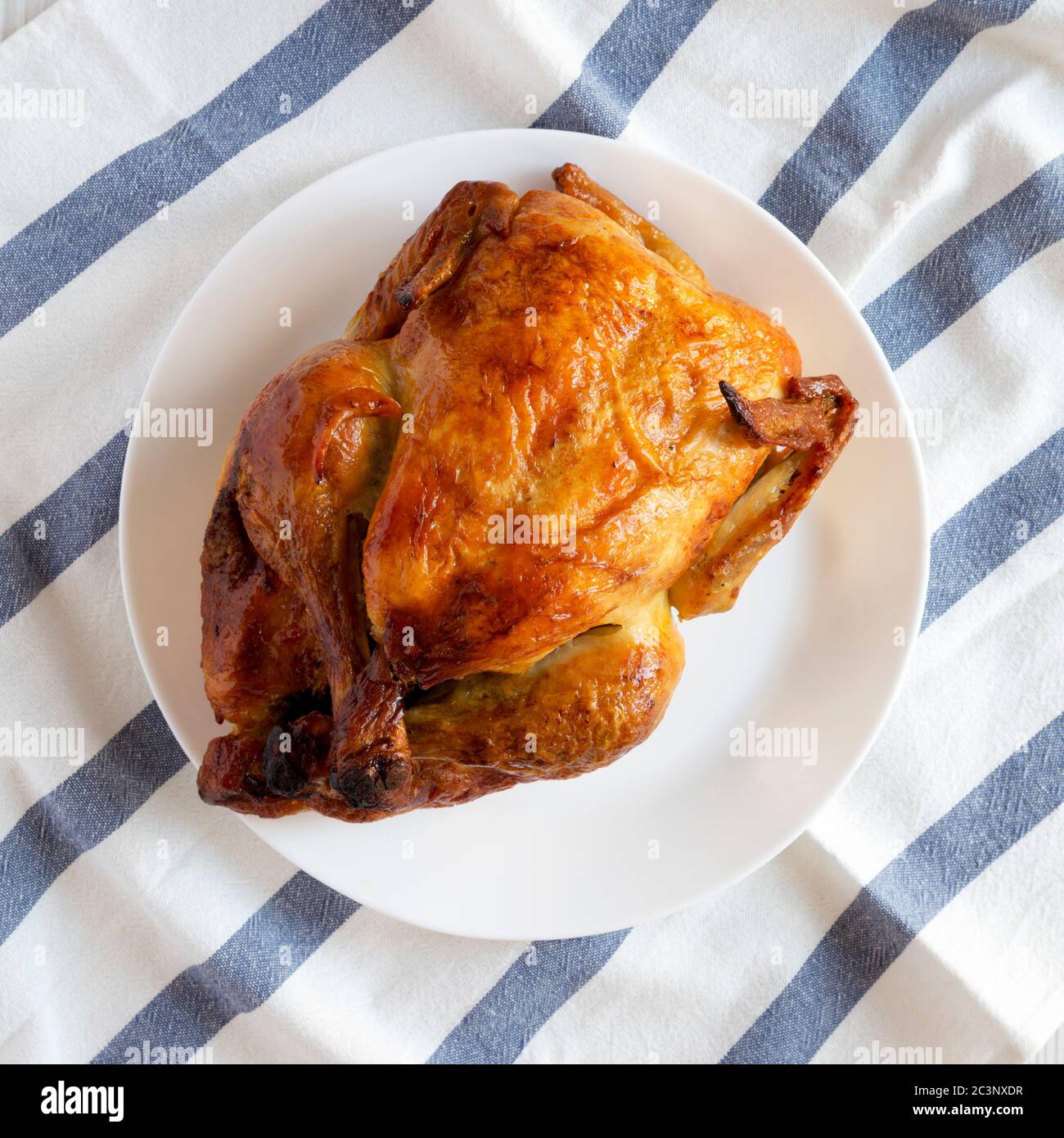 Homemade traditional rotisserie chicken on a white plate, overhead view ...