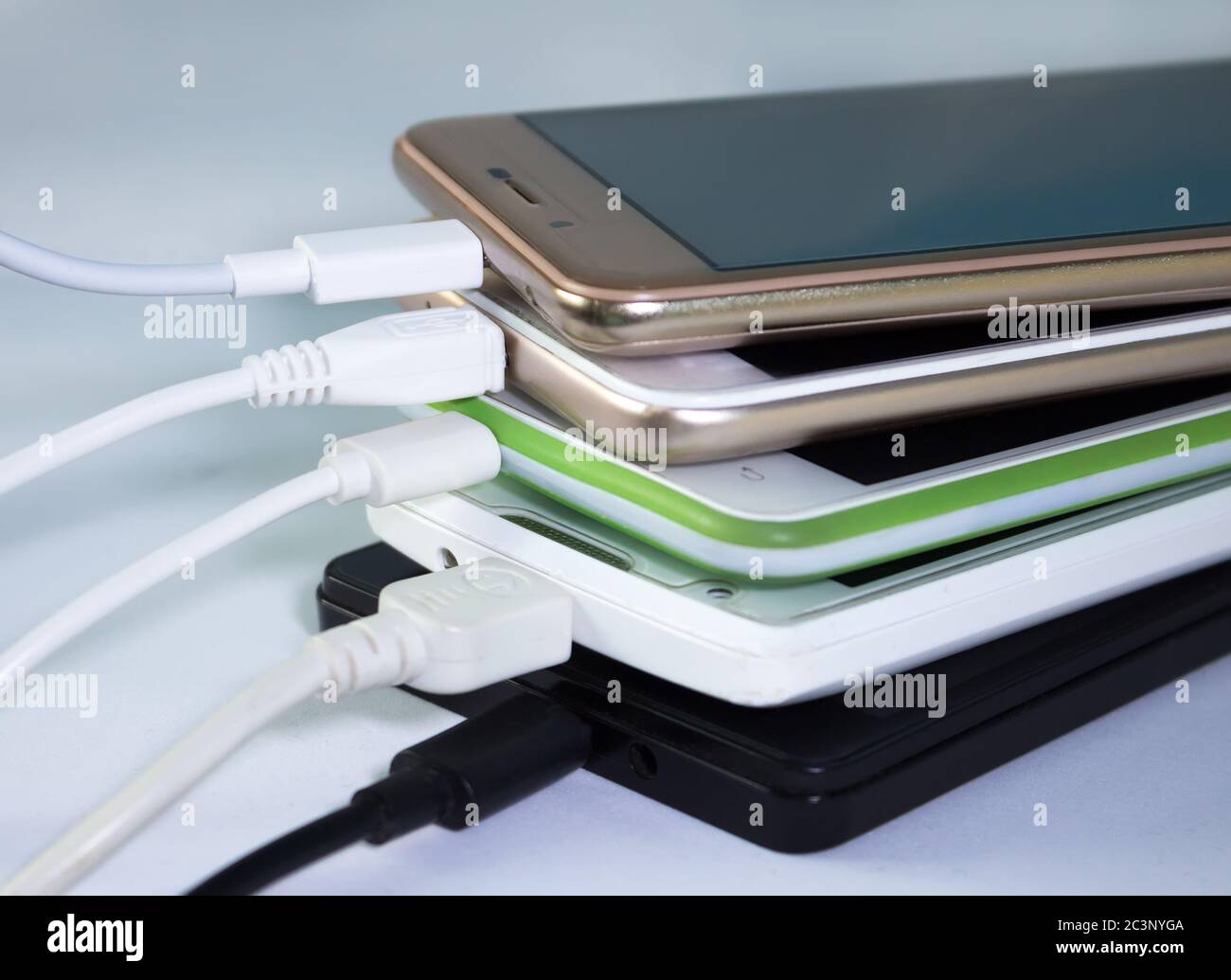 A pile of smartphones, charging through usb cables Stock Photo - Alamy