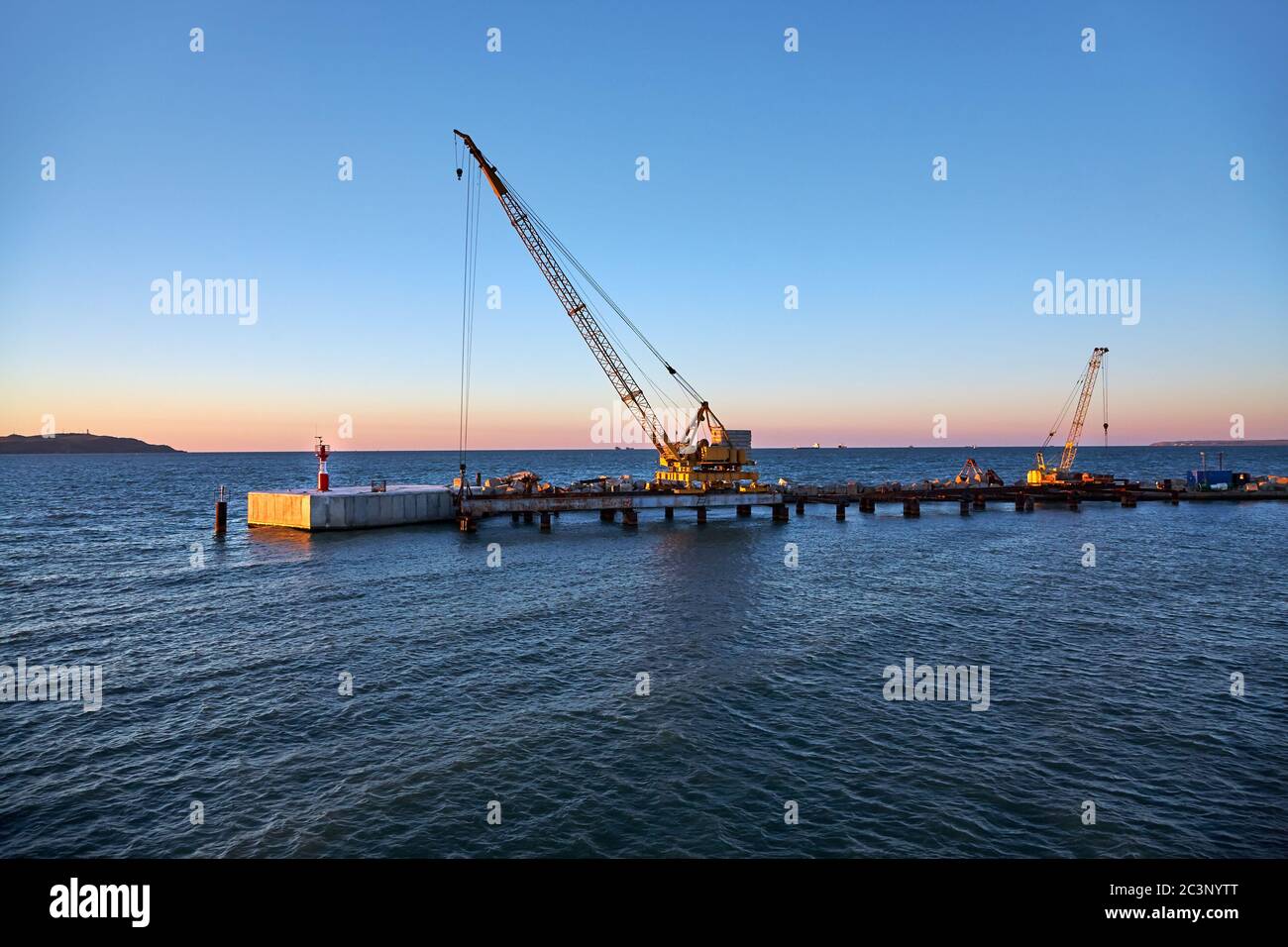 Port crane bridge and bulk carrier at sunset Stock Photo - Alamy