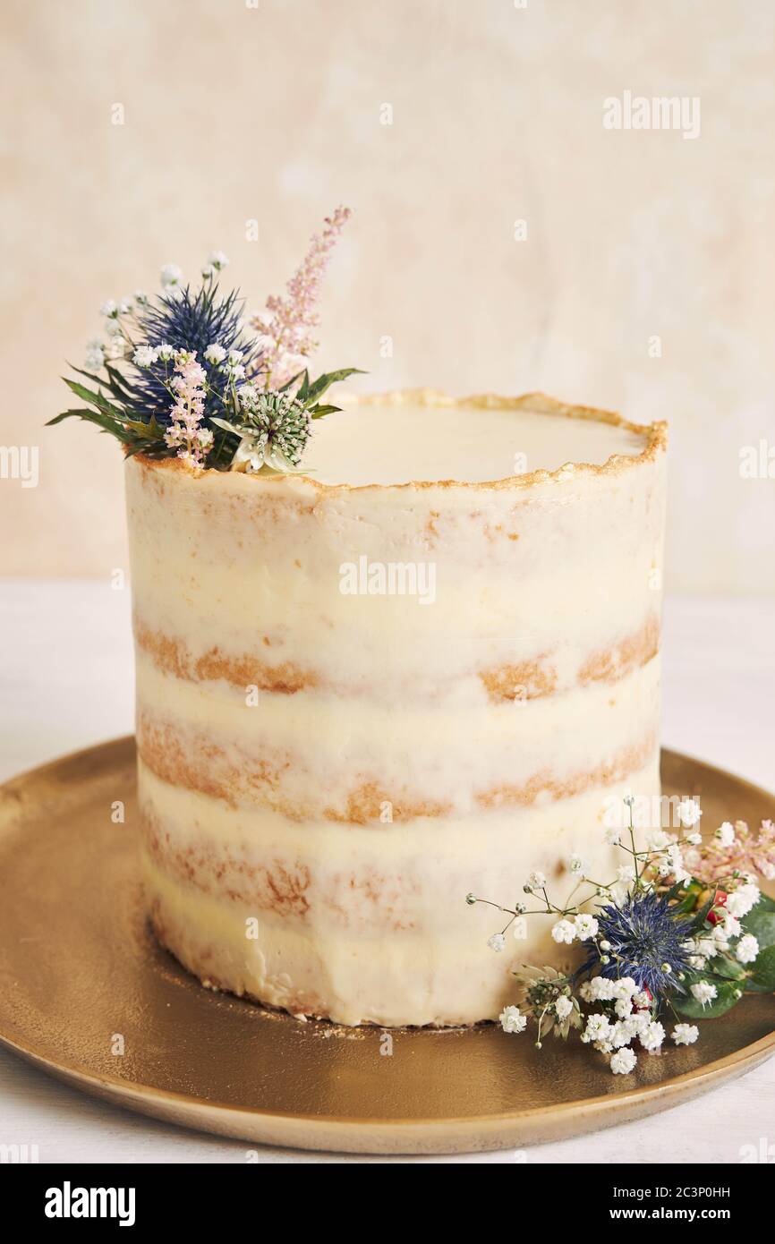 Vertical shot of a beautiful and delicious cake with flower and golden ...