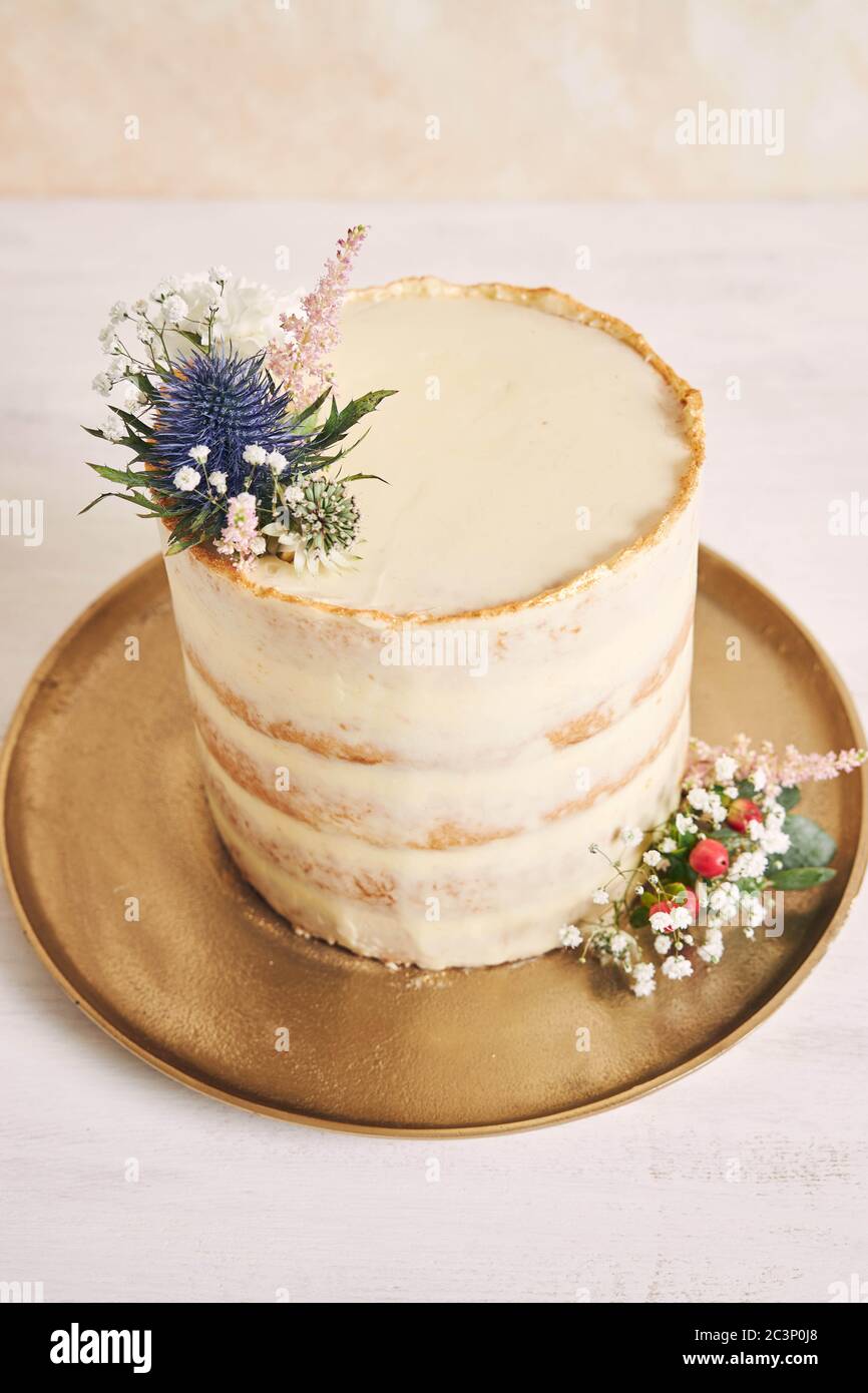 Vertical shot of a beautiful and delicious cake with flower and golden ...