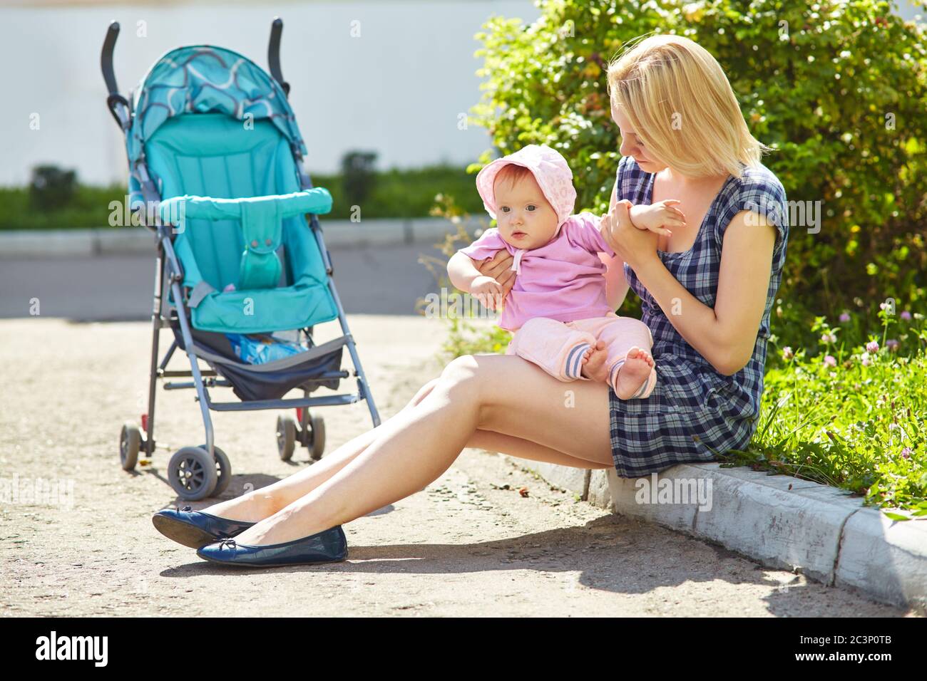 young mother walking with a baby sitting in a stroller. mom and little ...