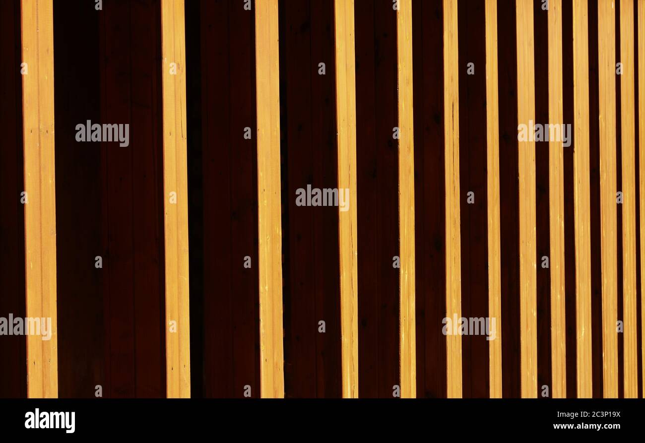 Yellow wooden columns with a dark background Stock Photo - Alamy