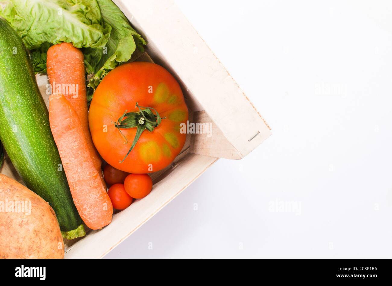 vegetables inside a wooden box. Tomatoes, carrots, zucchini and lettuce ...