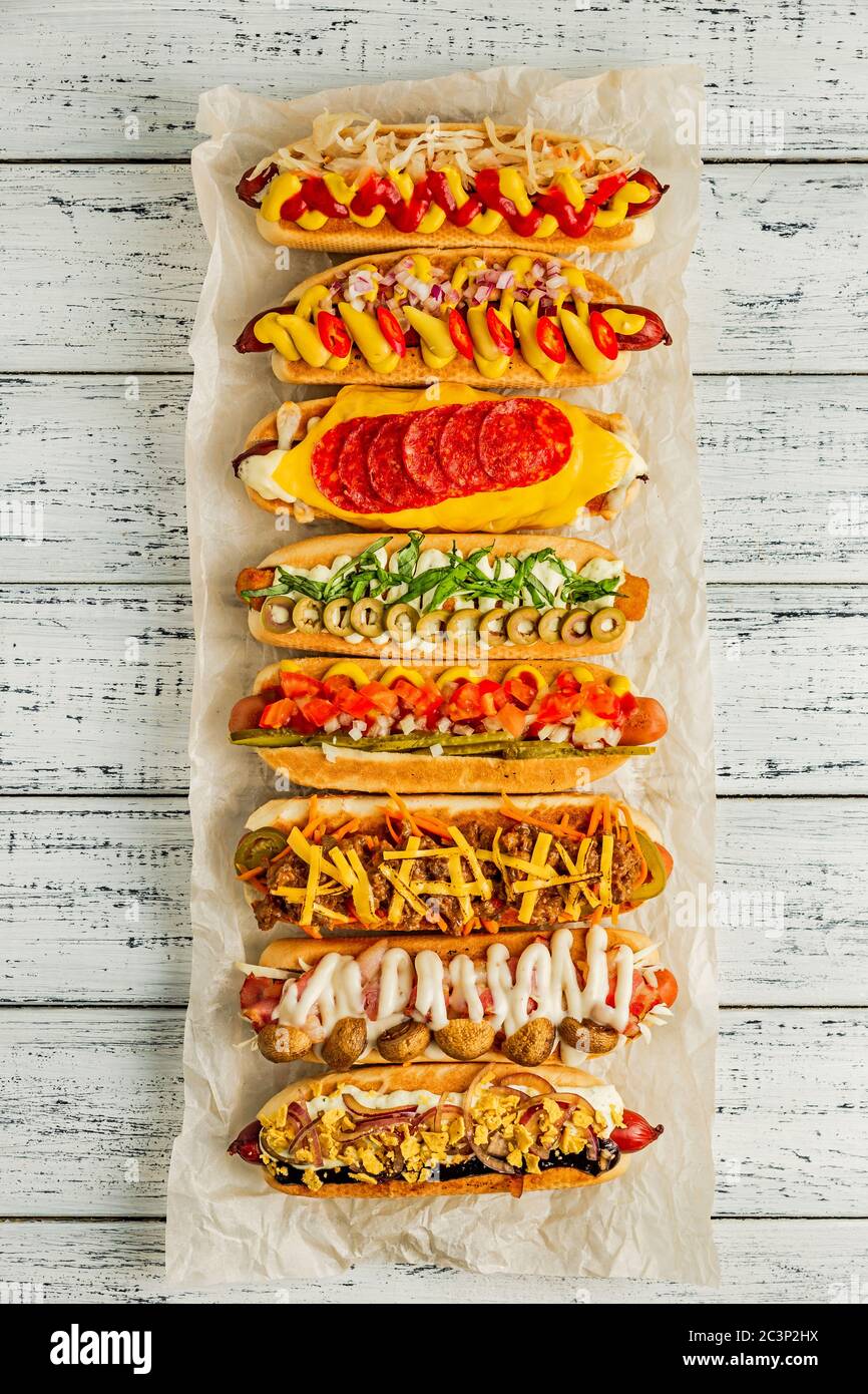8 different hot-dogs on white wooden table, shot from above Stock Photo ...