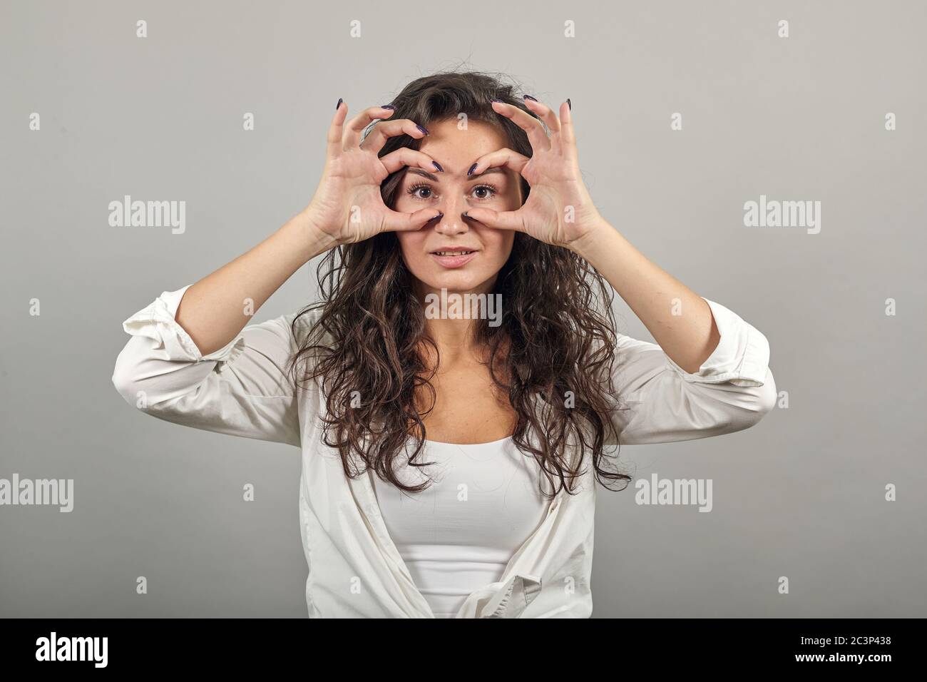 Making glasses of fingers, looking at camera and smiling, hold hands ...