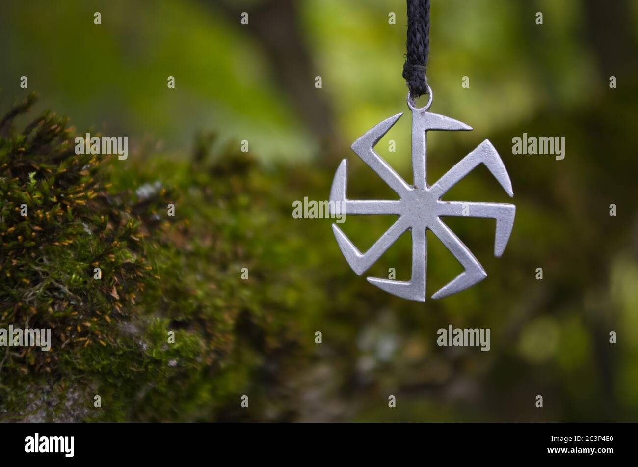 Pagan symbol Kolovrat on the background of moss Stock Photo - Alamy