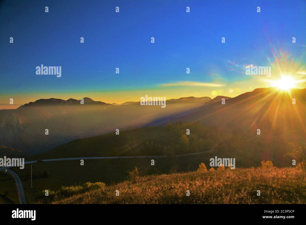Breathtaking view of the sunset in the sky over the beautiful hills and ...