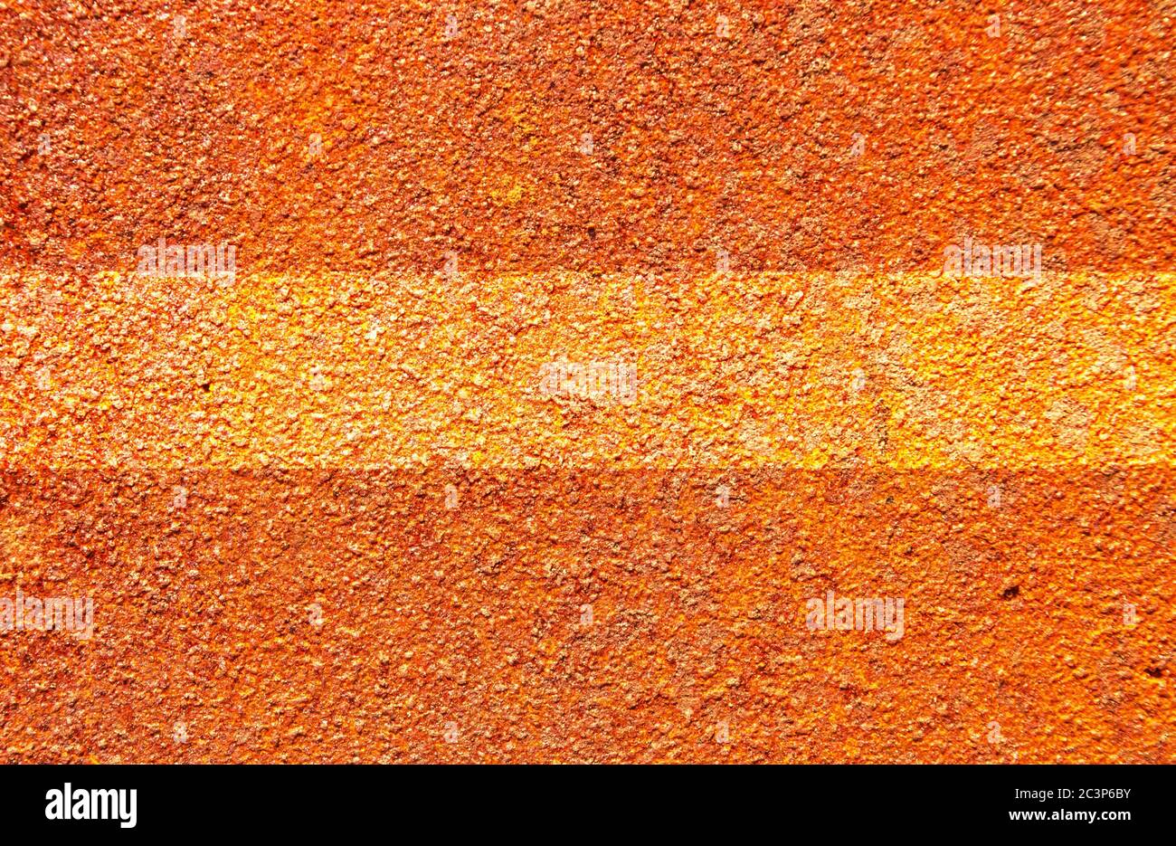 Closeup view of an orange rough surface with a light orange horizontal ...