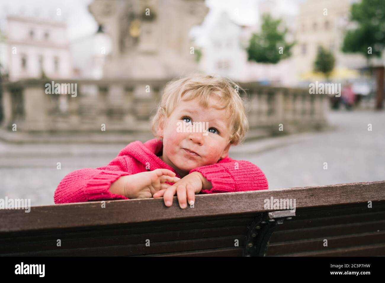 Little girl sitting on bench Stock Photo - Alamy
