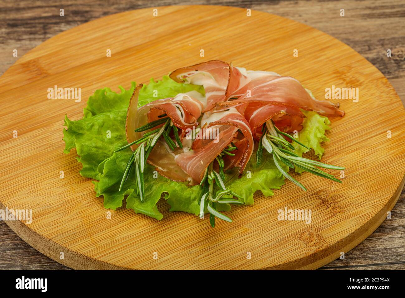 Sliced pork Jamon meat with rosemary Stock Photo - Alamy
