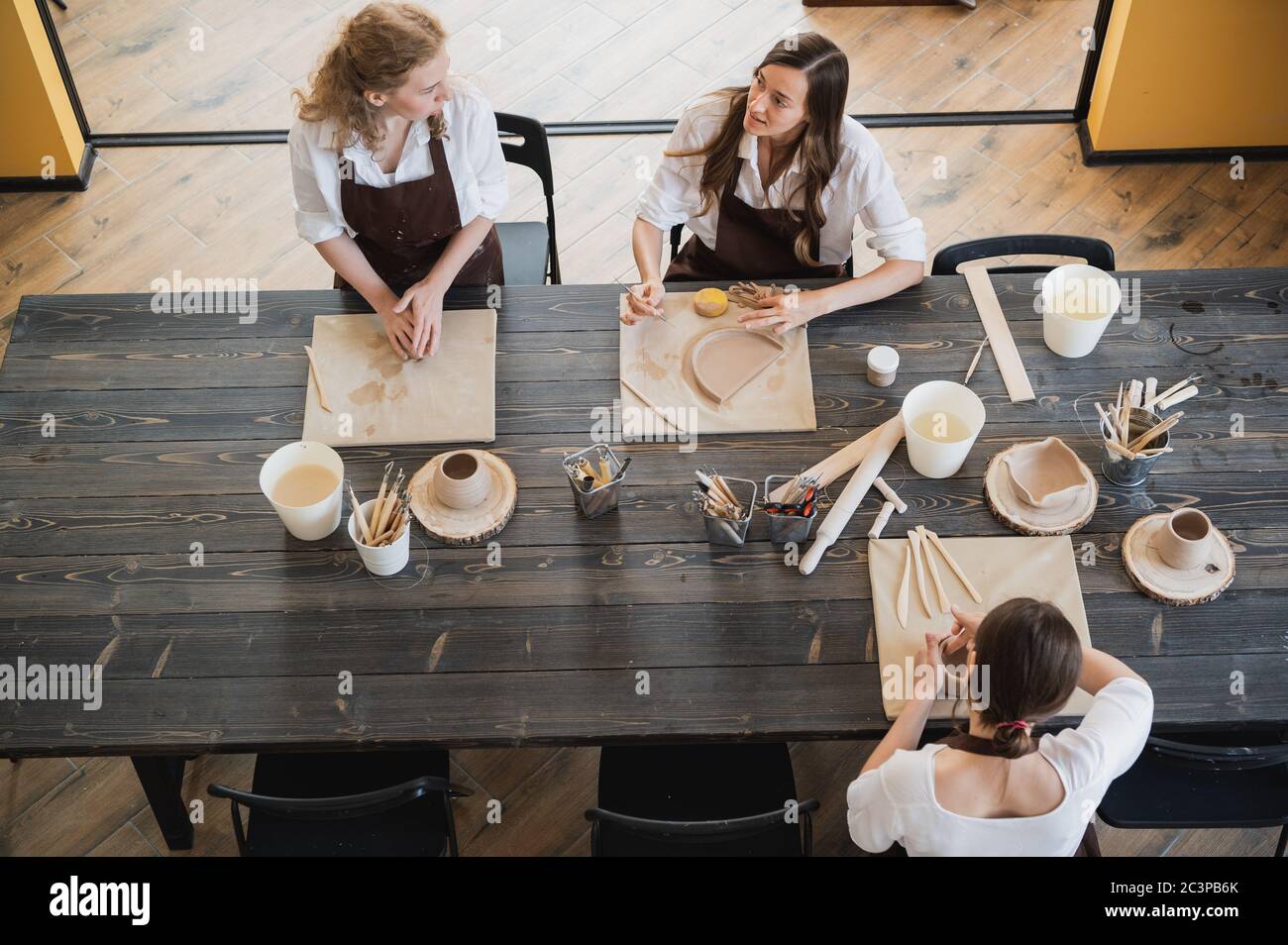 Beautiful young female artist girls creating handmade pottery in modern ...
