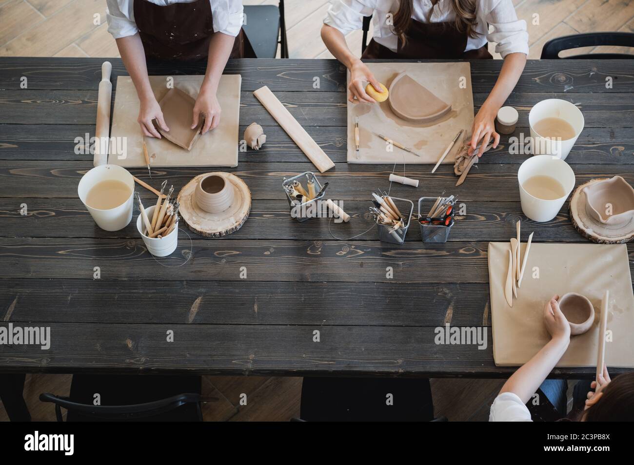 Beautiful young female artist girls creating handmade pottery in modern ...