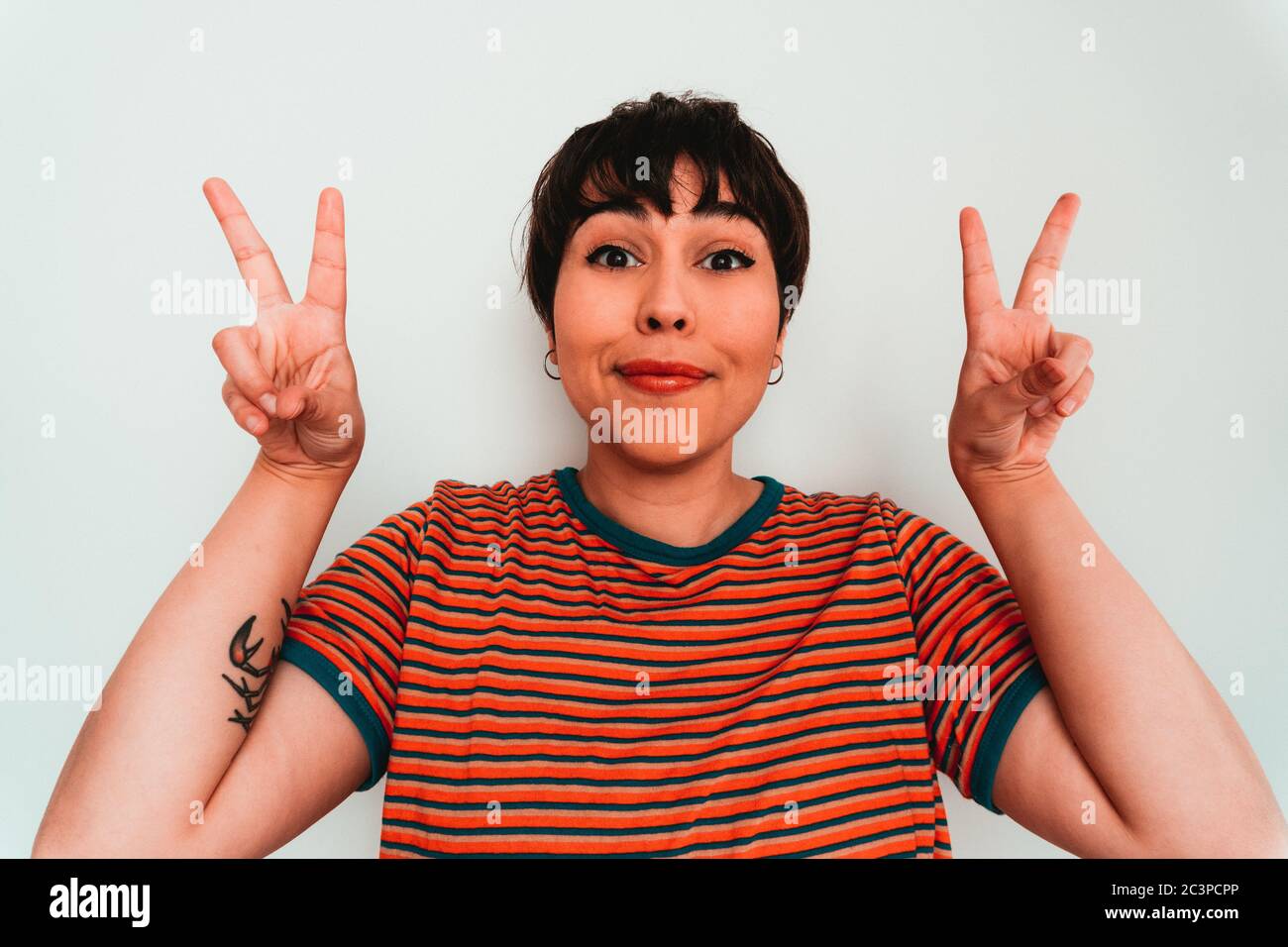 Happy woman showing peace sign with fingers Stock Photo - Alamy