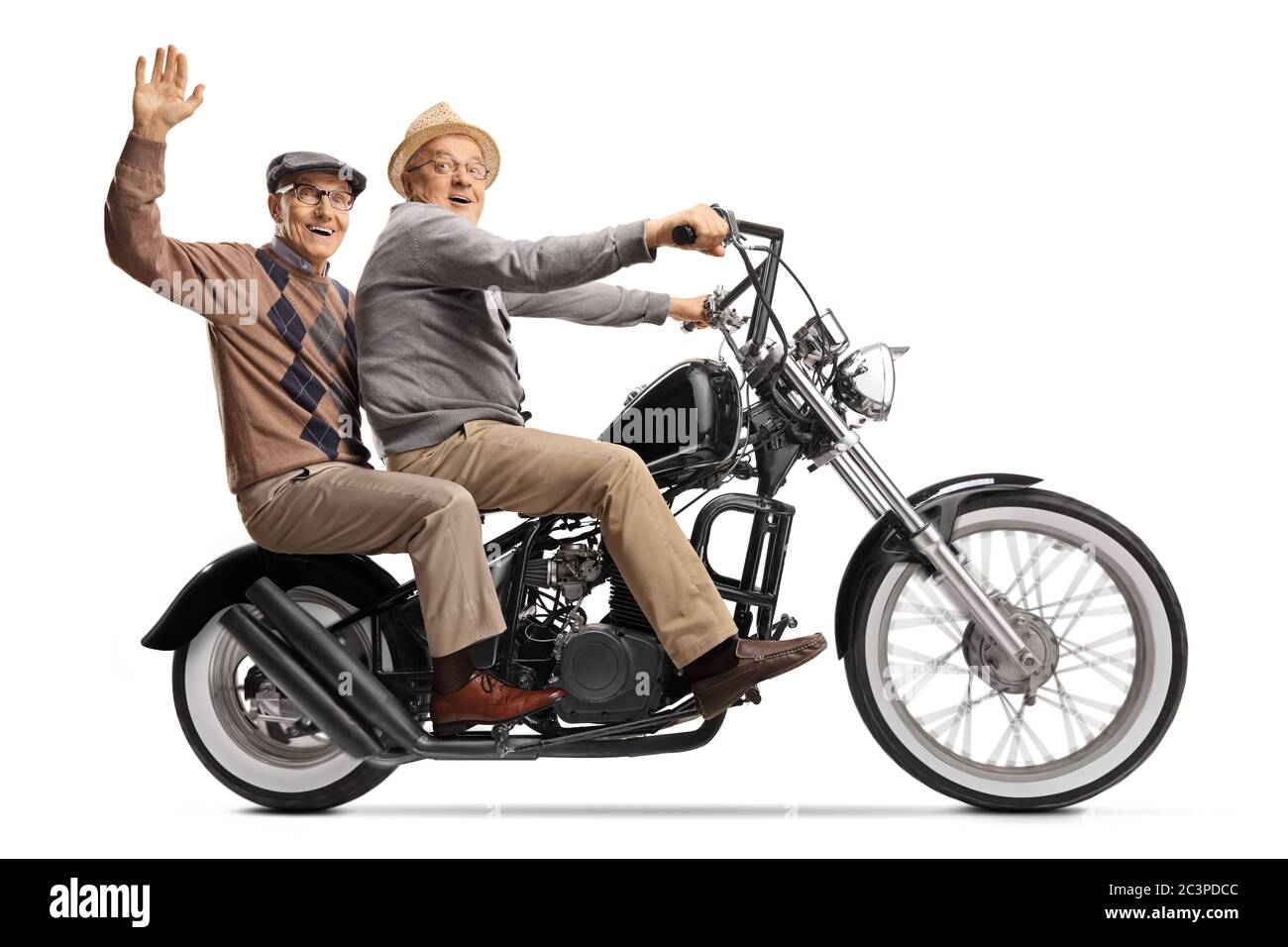 Two elderly men on a chopper motorbike waving and looking at the camera ...
