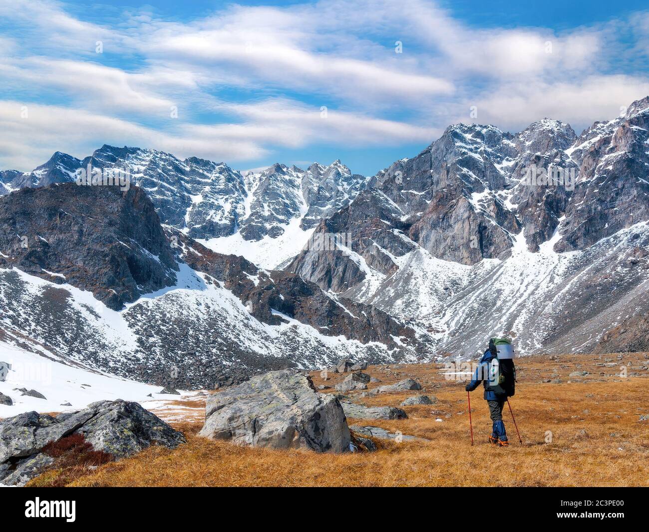 A tourist with a backpack walks through the valley among the rocks and ...