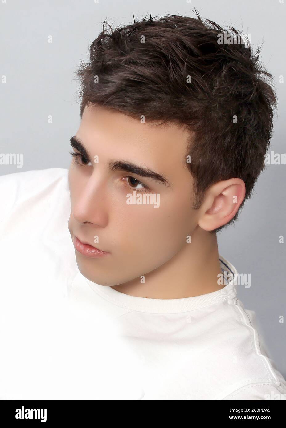 Attractive male model with short hair posing in studio on isolated ...