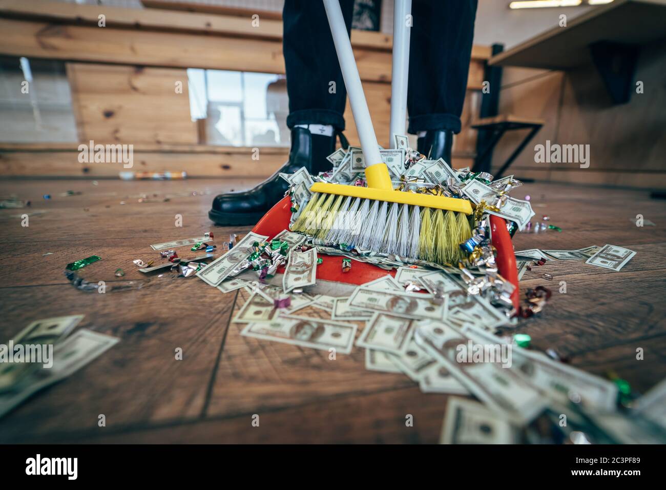 Broom sweeping dollars in scoop from on wooden floor Stock Photo - Alamy