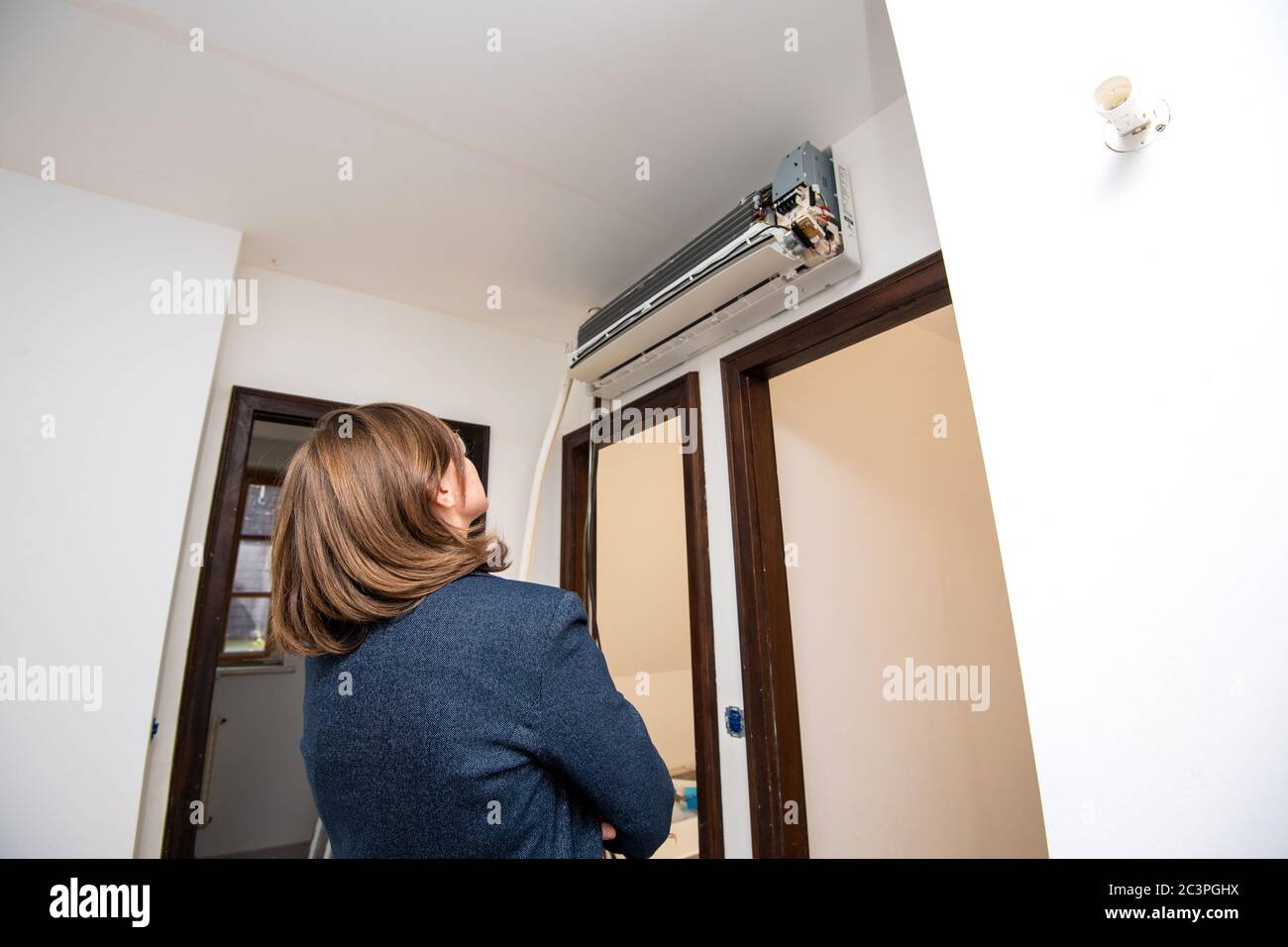 Side view of young woman admiring the newly installed unfinished AC air ...