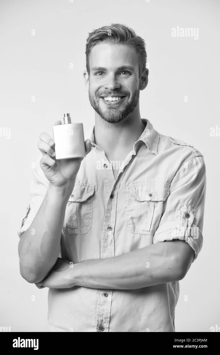 Overpowering mens scent. Happy guy hold perfume bottle yellow ...