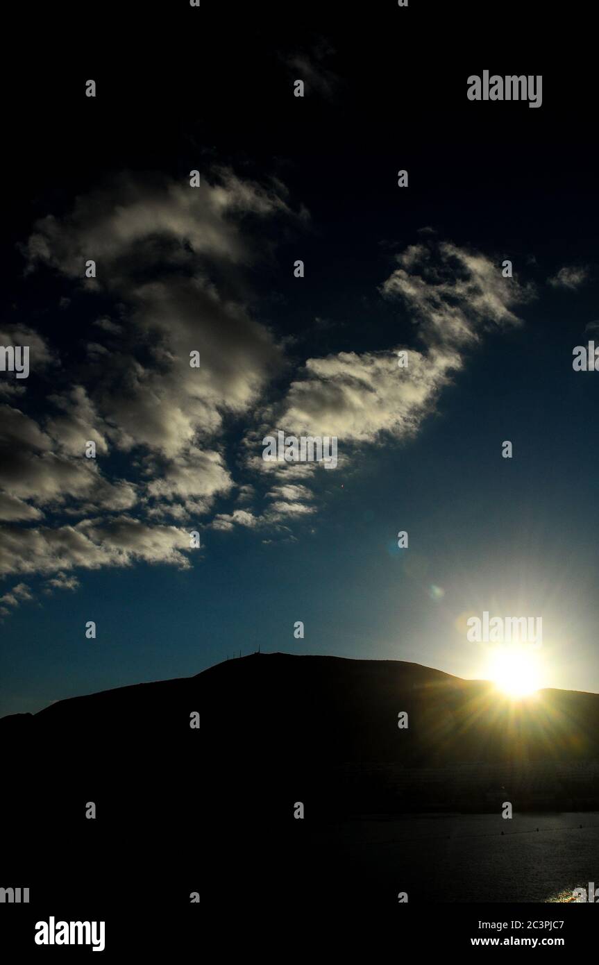 Dramatic Sunset Rays Behind Silhouette of a Mountain Stock Photo - Alamy