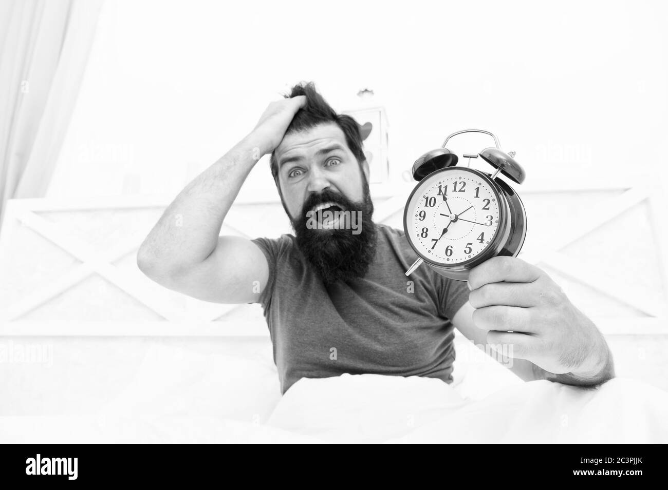 Totally overslept. Get up right now. Stressed man alarm clock. Sleepy ...