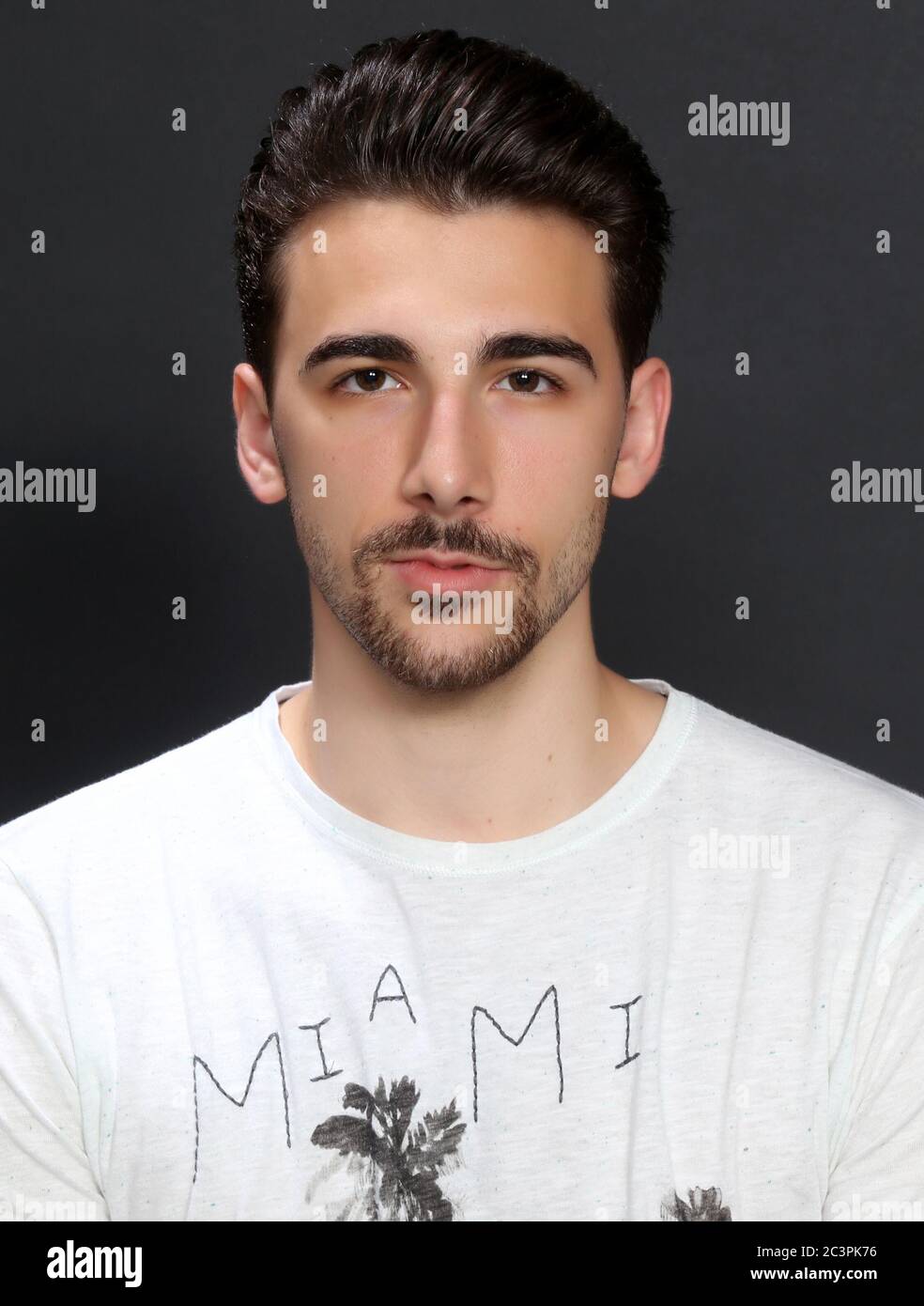 Attractive male model with short hair posing in studio on isolated ...
