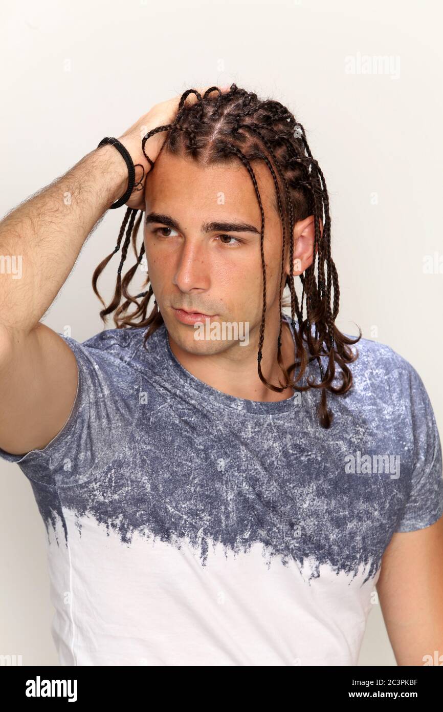 Attractive, caucasian male model with braids posing in studio on ...