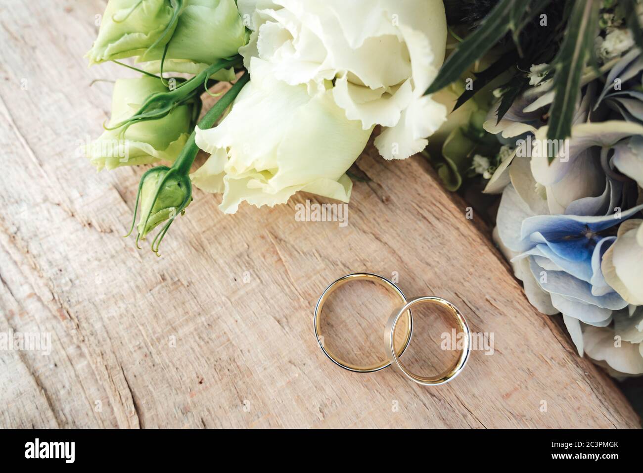 Top view up of couple of wedding rings laying on rough wooden table ...