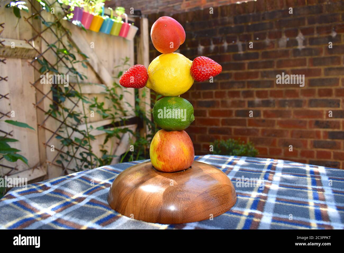 Fresh fruits sculpture. Apple lemon lime peach strawberries atop a ...