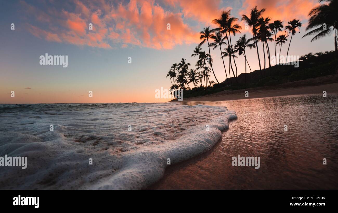 Beautiful shot of a seascape of the waves on the beach and silhouettes ...