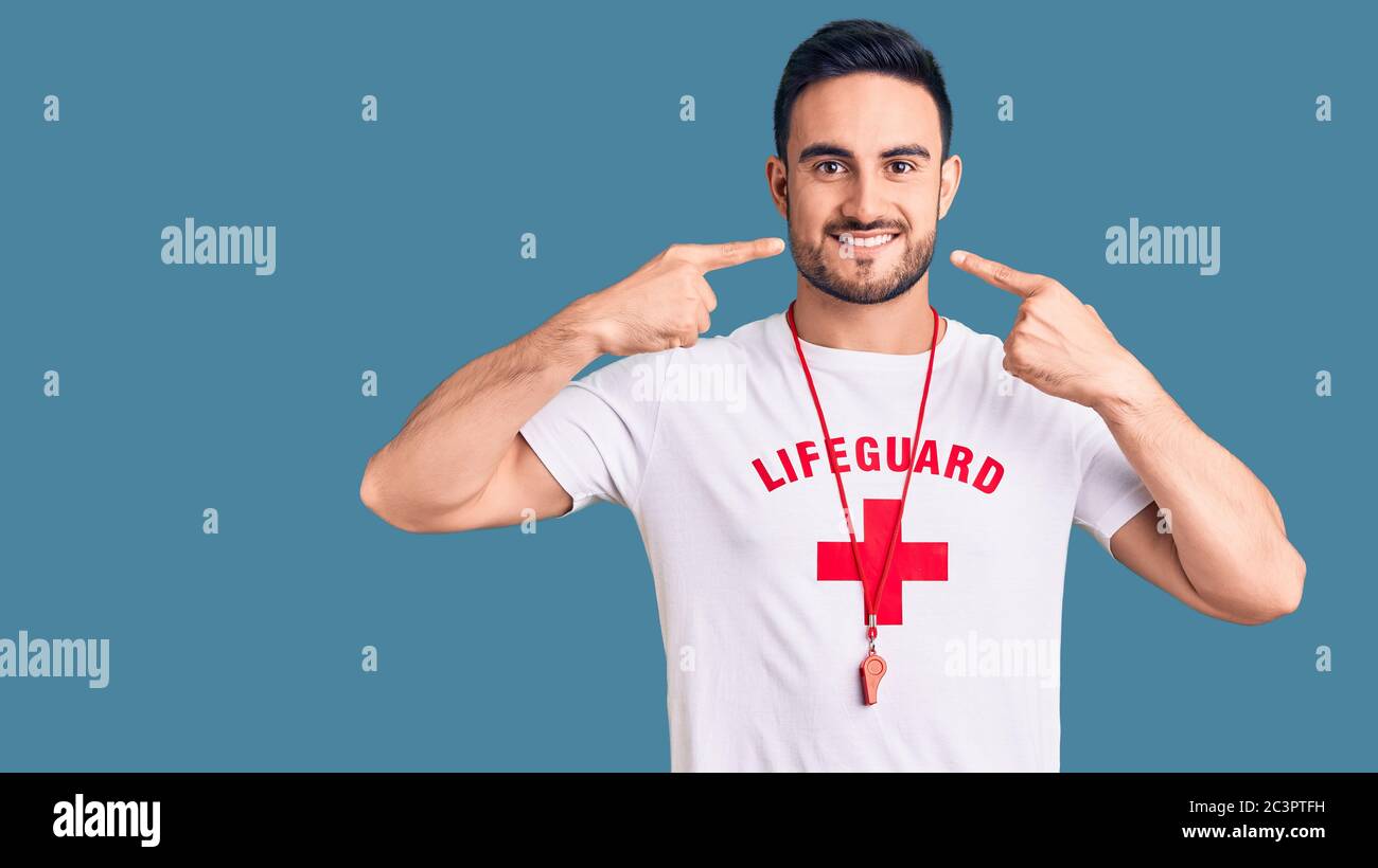 Young handsome man wearing lifeguard uniform smiling cheerful showing ...